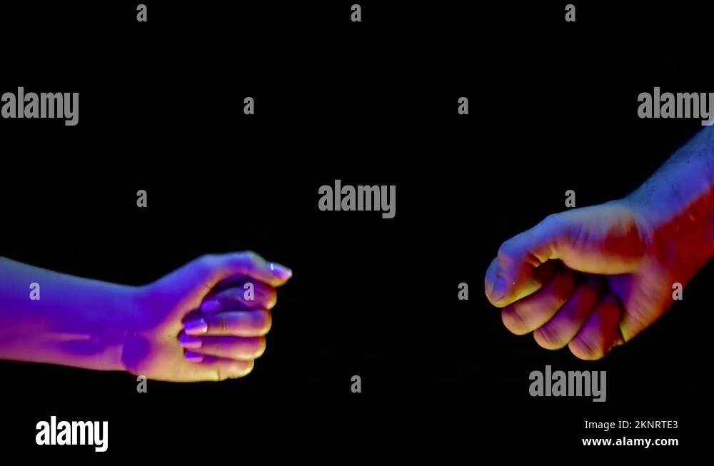 Couple play rock paper scissors, hand game on black background under ...