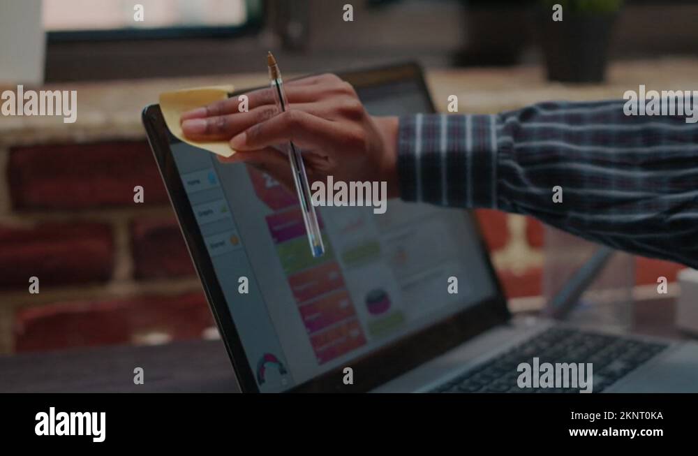 Employee putting sticky notes on laptop screen as work reminder Stock ...