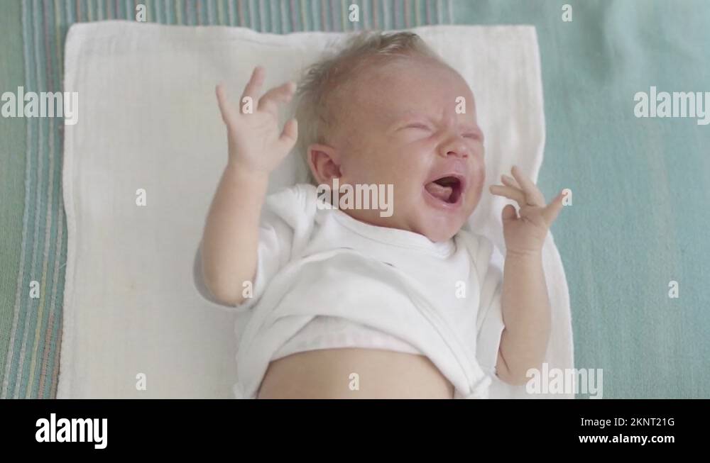 Toddler girl crying on a bed. Changing diapers of a newborn baby Stock ...