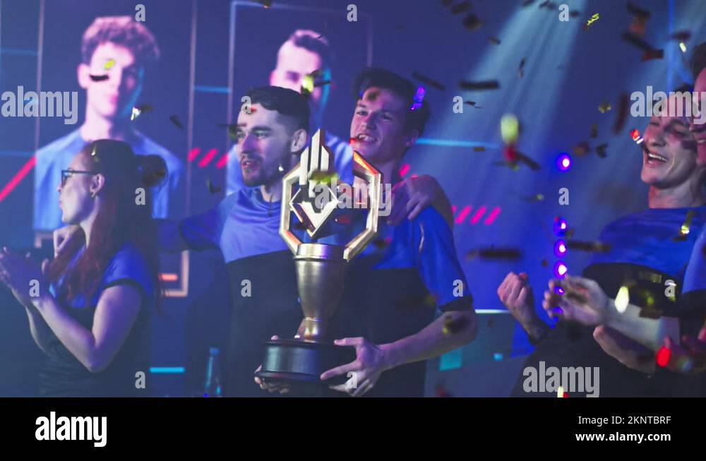 Team of gamers with golden cup celebrating victory Stock Video Footage ...