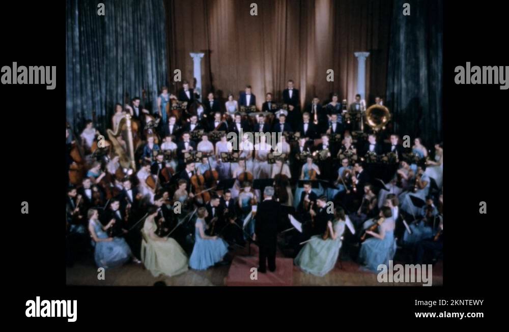 1950s: Man holding clapperboard, clapping. Orchestra holding ...