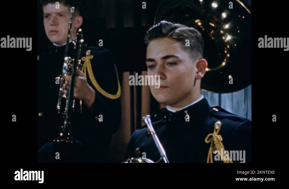 1950s: Hands holding clapperboard, clapping. Man playing French horn ...