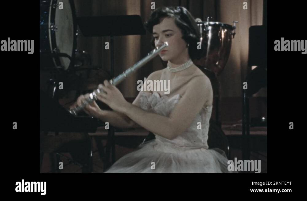 1950s: Man holding clapperboard, clapping. Woman sitting on stage ...