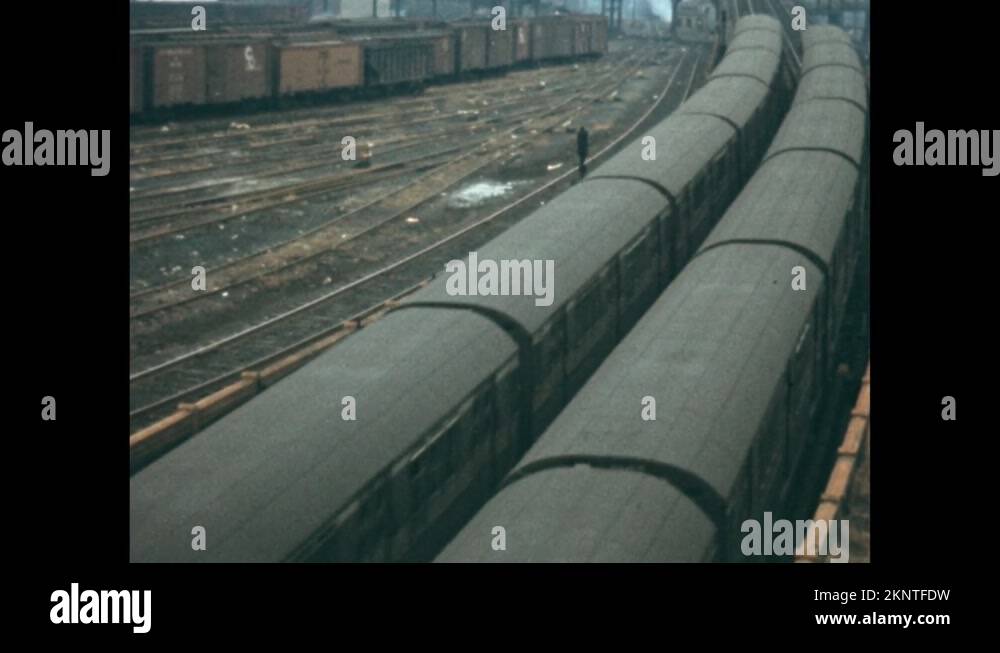 1950s: Subway trains pass each other on tracks of railyard. Crowds of people Stock Video Footage ...