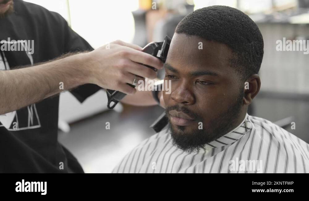African American at the barbershop. Handsome black man getting his ...