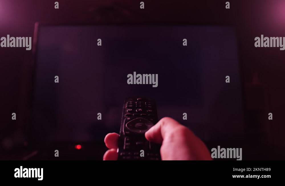 Man watches smart TV and uses remote control. Person controls TV using ...