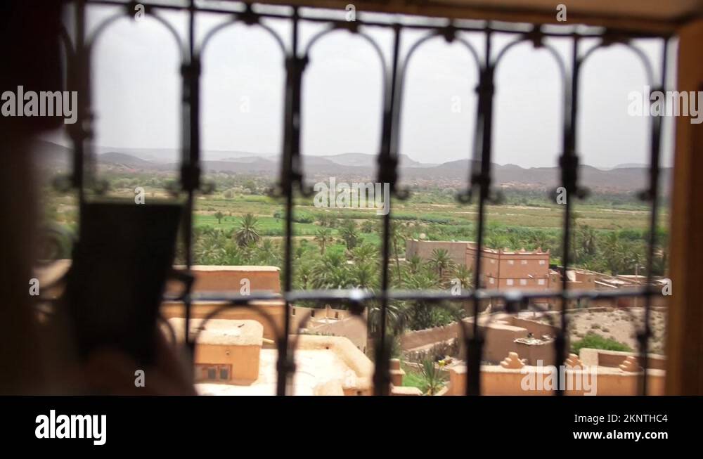 Girl looking out the window of Moroccan Village in a Desert Oasis with ...