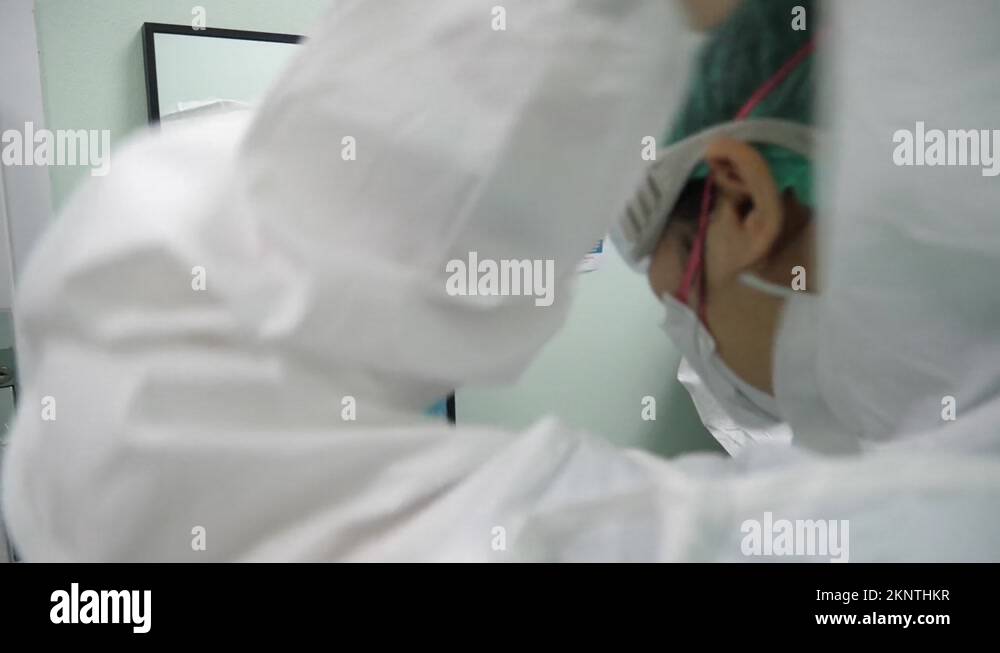 Medic Staff Putting On PPE Suit Infront of The Mirror Due To COVID-19 ...