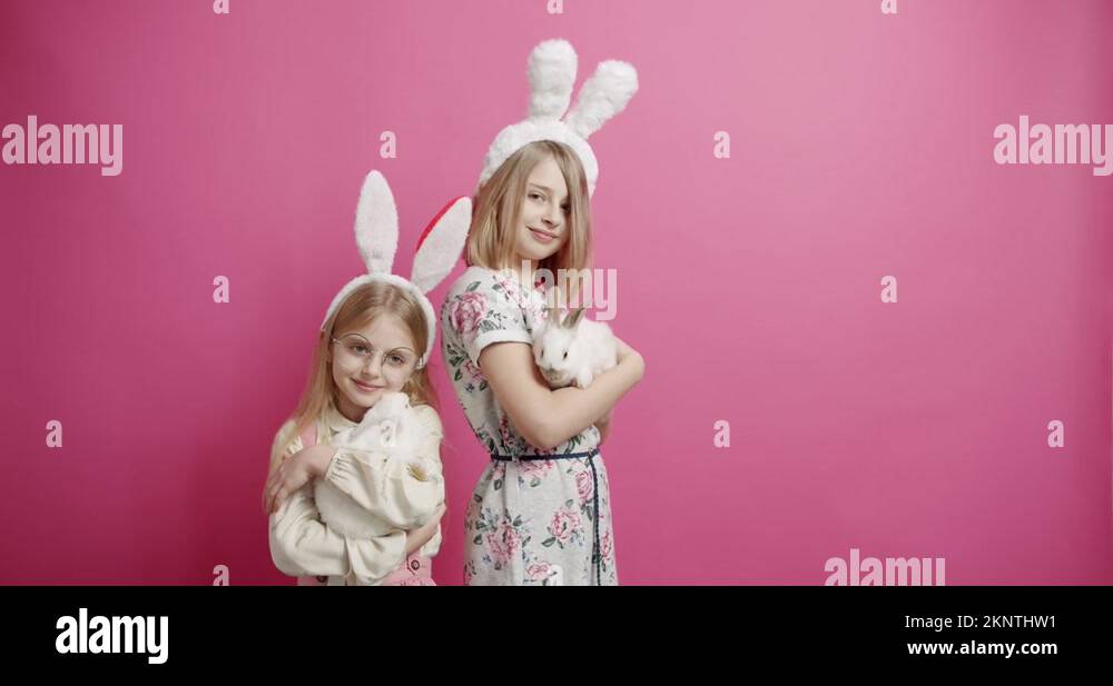 Cute Girls With Rabbit Ears Playing with the Rabbit on an Isolated ...