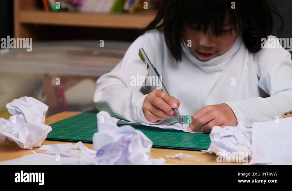 Child cutting paper with cutter knife alone, dangerous situation at ...