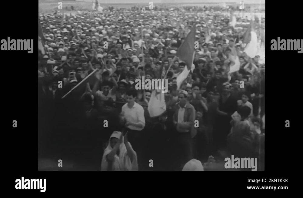 Algeria 1960s: Crowd waving Algerian flags. Ahmed Ben Bella speaking ...