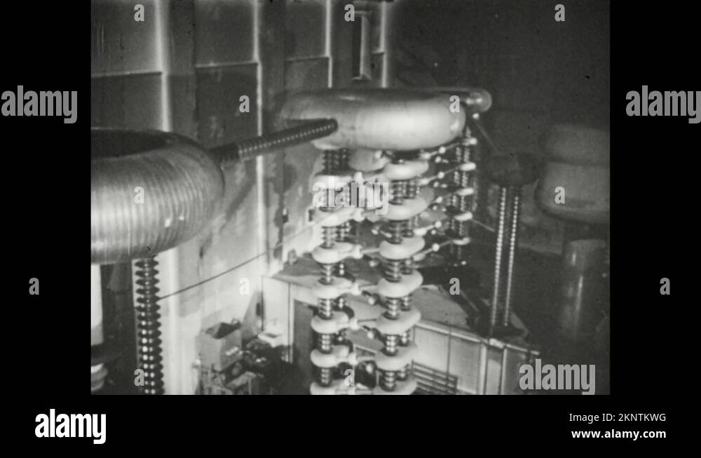 1940s: Man with long stick points to large electrode towers in particle ...