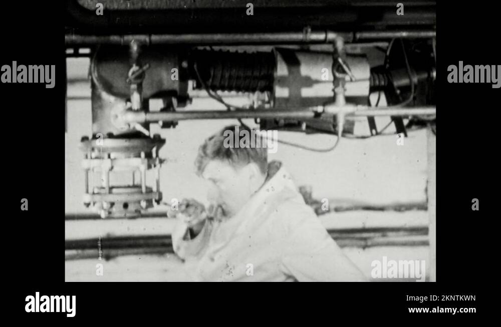 1940s: Van de Graaff generator stands in atomic lab. Man adjusts Van de ...