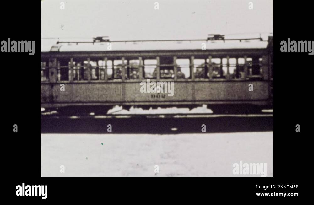 1940s: Streetcar driving, zoom out. Man watching machine parts lowering ...