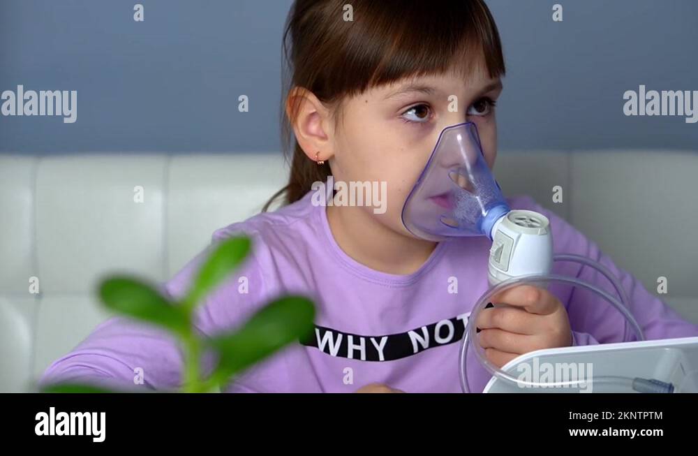 Little girl turn on nebulizer to make inhalation with medical inhaler ...