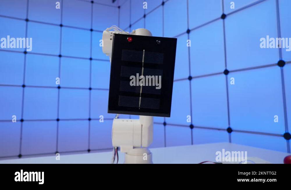 Solar panel in the robot arm. Robot holding a solar panel on a blue lab ...