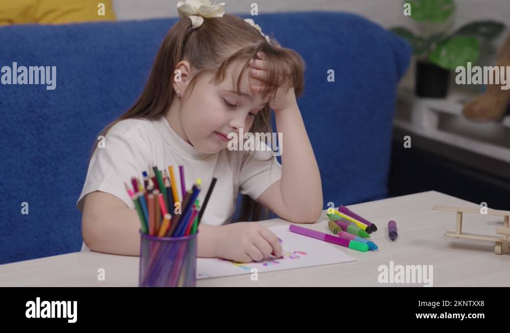 little child girl draws bright colorful drawing with crayons, children ...