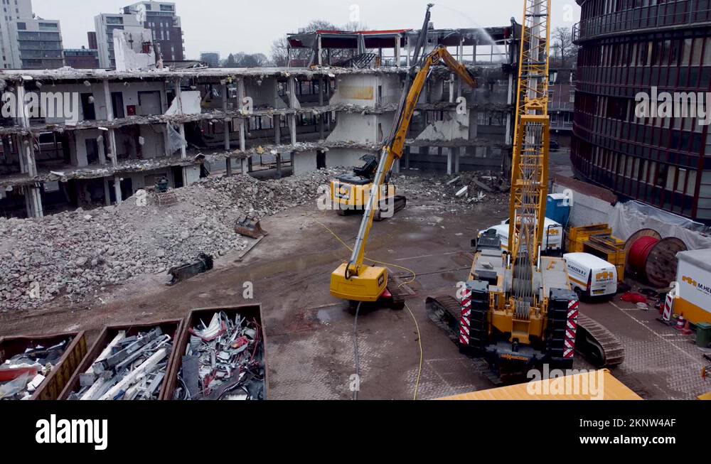 Demolition of a police station using building hydraulic shears, aerial ...