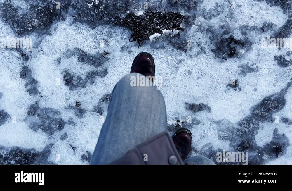 Man in boots steps on ice and makes it crack at frozen lake Stock Video ...