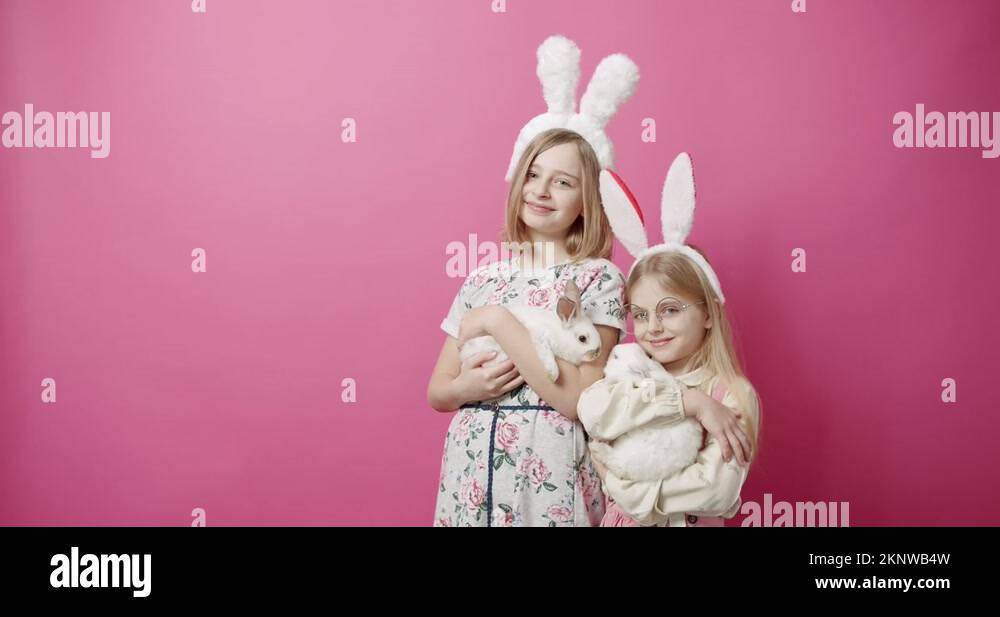 Cute Girls With Rabbit Ears Playing with the Rabbit on an Isolated ...