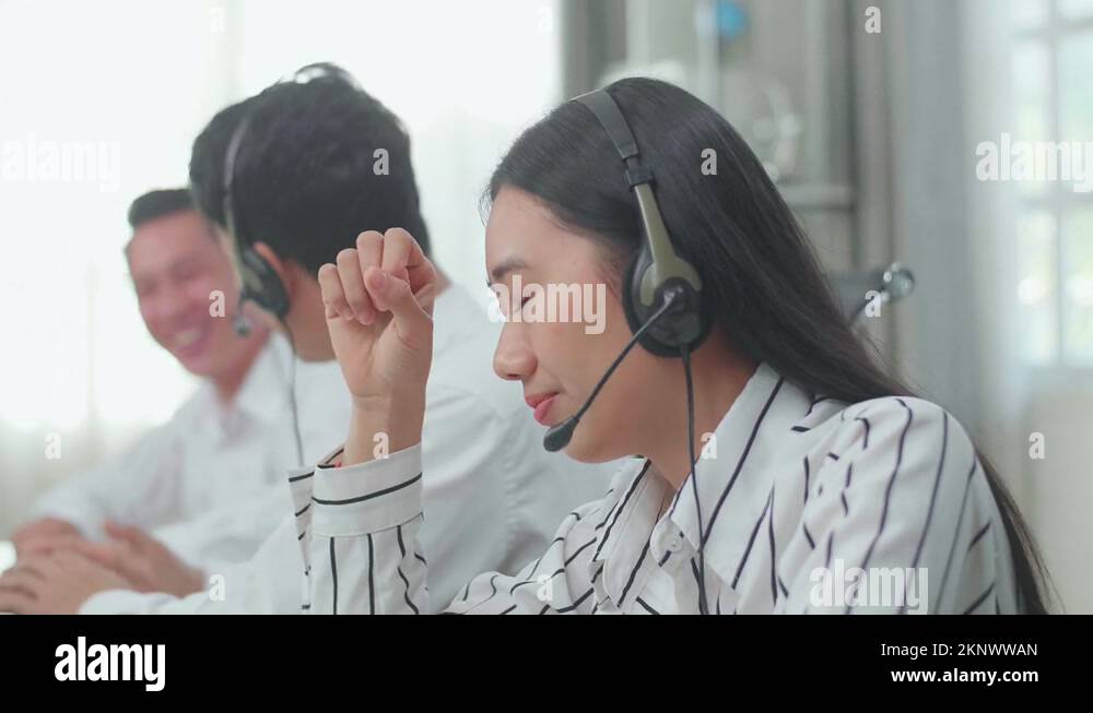 A Woman Of Three Asian Call Center Agents Wearing Headset Is Tired ...