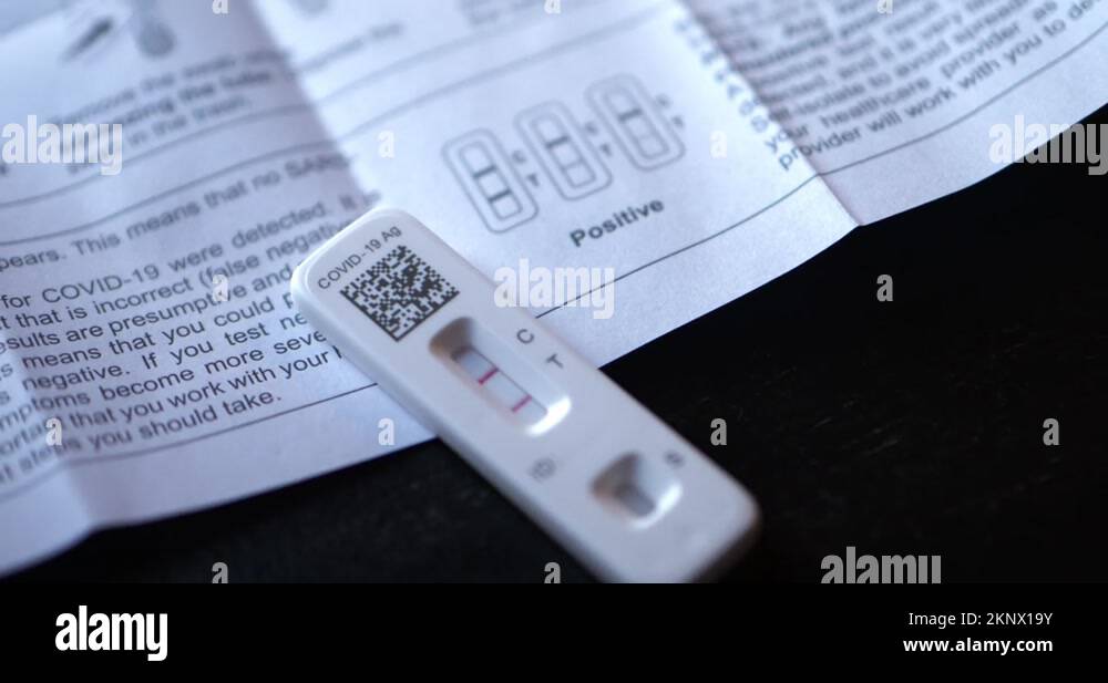 Covid 19 positive at home antigen test kit on black table with ...