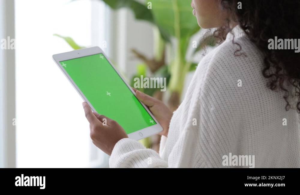 African American black girl using iPad tablet viewing green screen ...