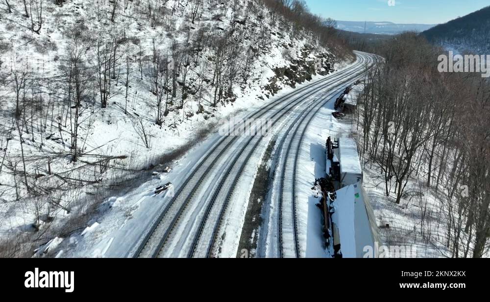 Train cars derail in winter ice and snow storm. FedEx train trailer ...