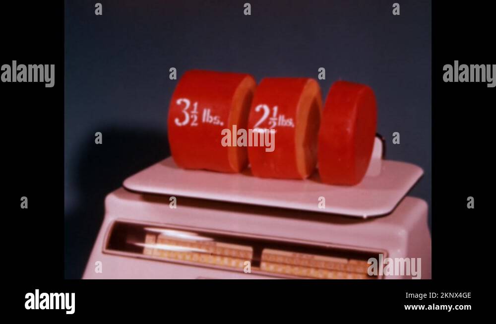 1960s: Three, red, cylinder objects sit on scale, two are labeled with ...
