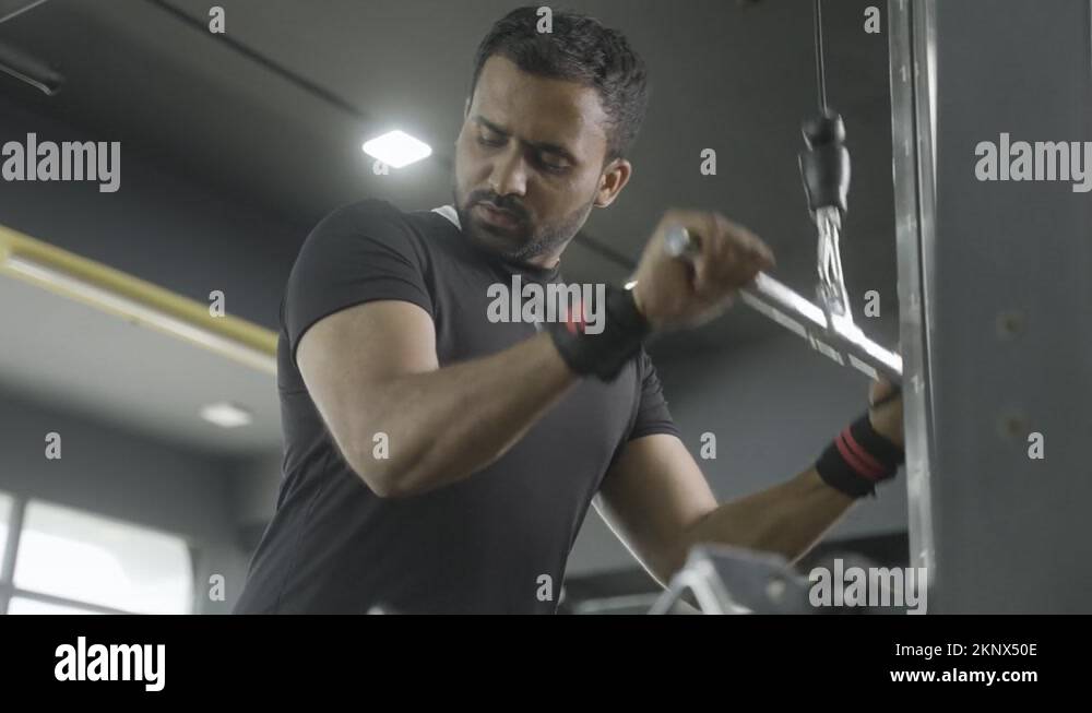 Young indian bodybuilder doing biceps workout at gym - concept of body ...