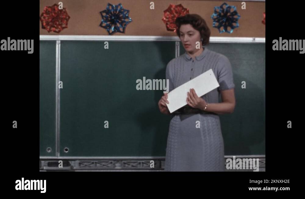 1960s: Teacher talking in front of classroom, places cards of words and ...