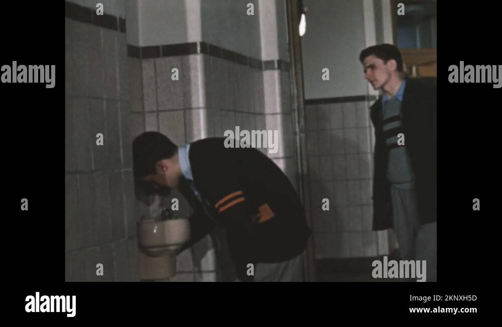 1950s: Boys stand in school hallway and talk while students exit ...