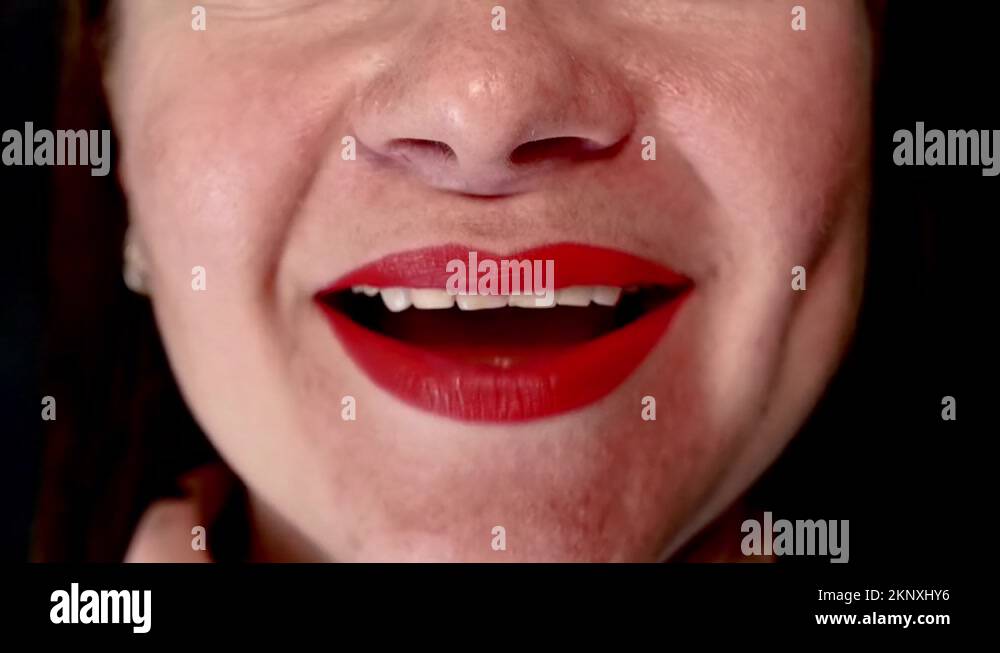 Woman with lips painted with red lipstick sings song opening mouth wide ...