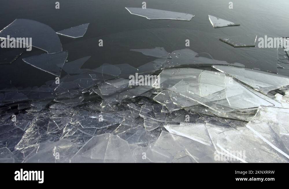 Sheets of ice shifting on frozen lake as the surface moves in winter ...
