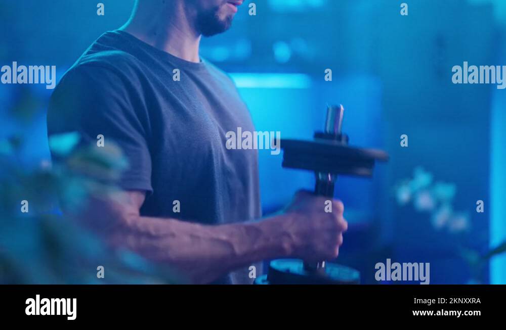 Headless male person at home in kitchen doing biceps dumbbell curl ...