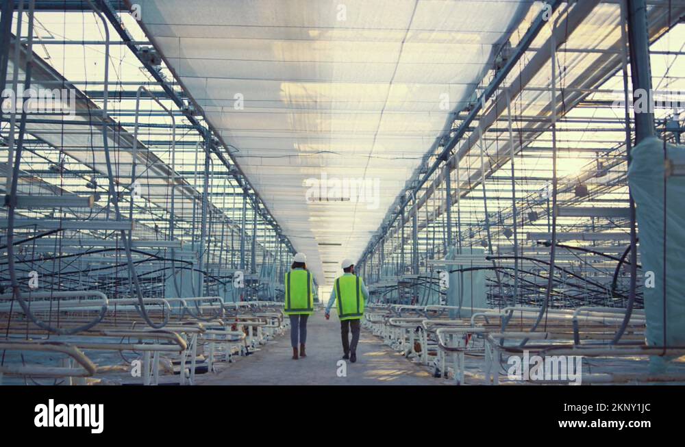 Engineers walking empty factory discussing production process plan in ...