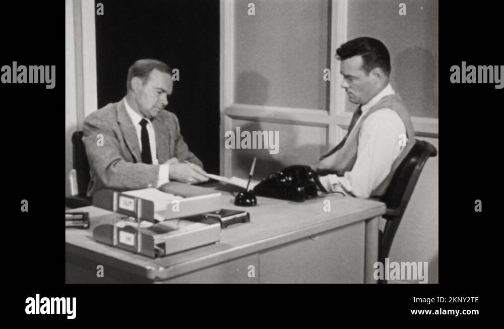 1960s: A manager and his employee sit across desk from each other ...