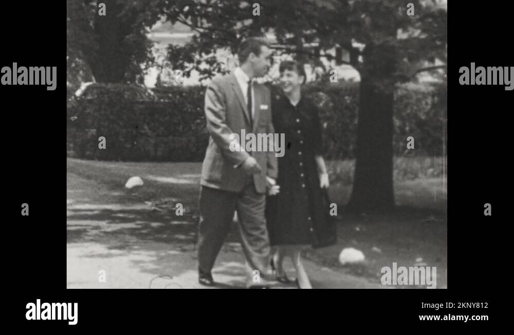 1950s: Man and woman walk down street. Man and woman stand in room ...