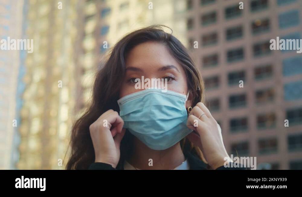 Asian brunette take off mask close up. Healthy safety life in big city ...