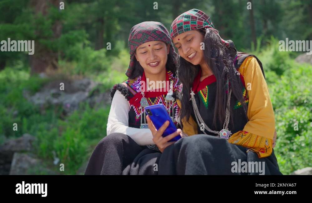 Two young Indian Village Women wearing traditional attire using Mobile ...