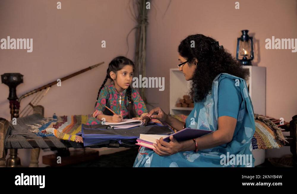 A tuition teacher helping a sweet village school girl to complete her ...