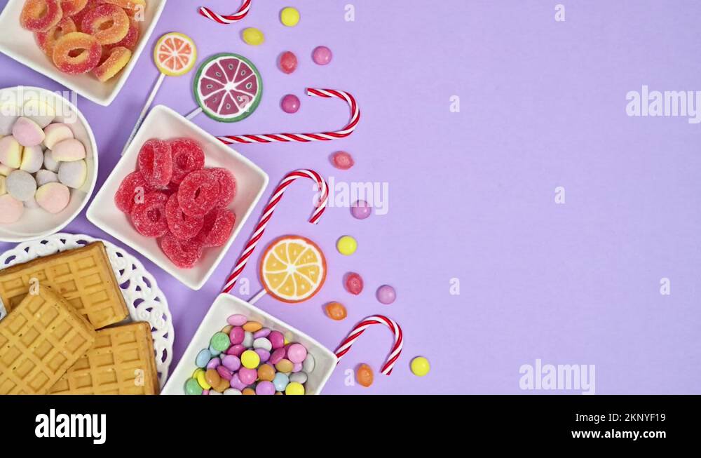 Pastel purple background with sweets, candies and lollipops. Stop ...