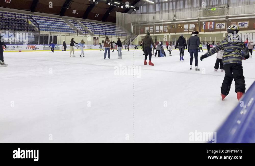 People ice skating in the hockey arena. Ice rink with various smiling ...