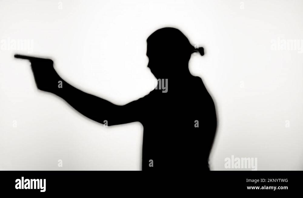Man holding gun close-up, shadow silhouette of hand with pistol. Horror ...