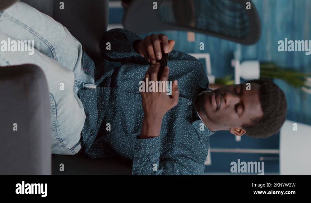 Vertical video: Exhausted african american man falling asleep while ...