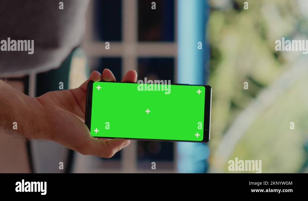 Vertical video: Person holding mobile phone with green screen ...