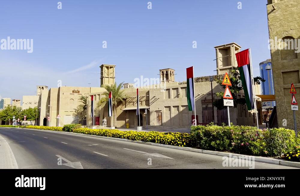 Traditional Arab Buildings With Wind Towers And UAE Flags Along Al Seef ...