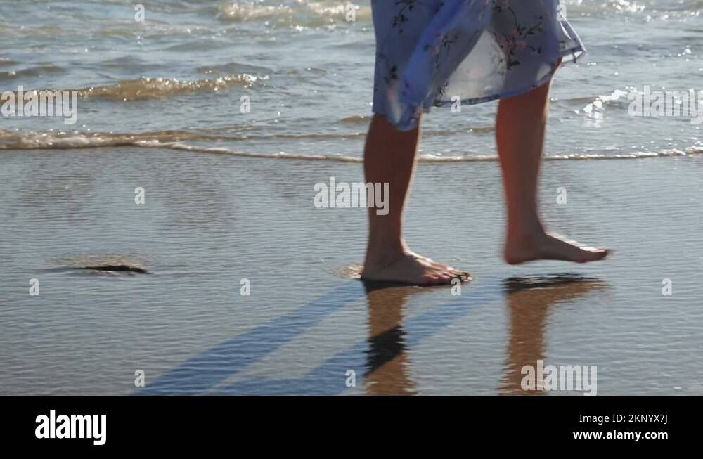 Female feet walking on sandy beach leaving footprints. Barefoot woman ...