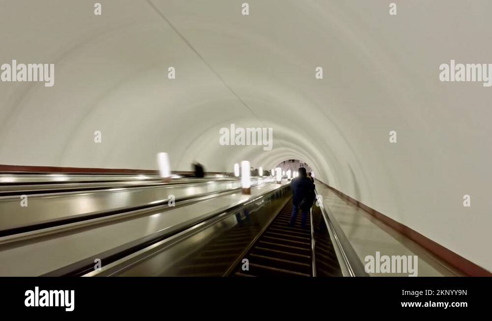 Descent down an old-fashioned escalator into a deep station of the ...