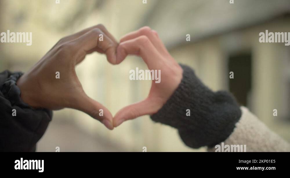 Multiracial couple making a heart shape with their hands, equality and ...